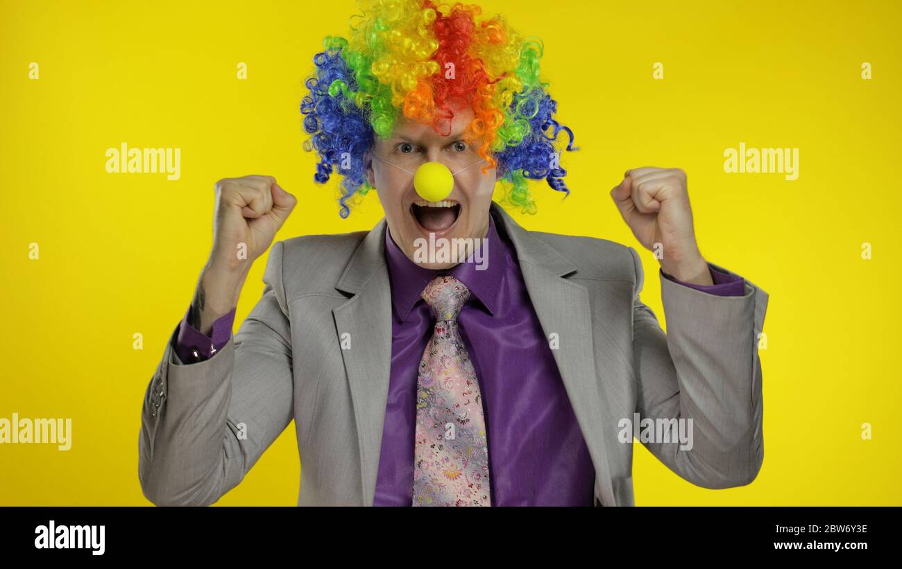Clown manager office worker in wig and business suit dancing, celebrate ...