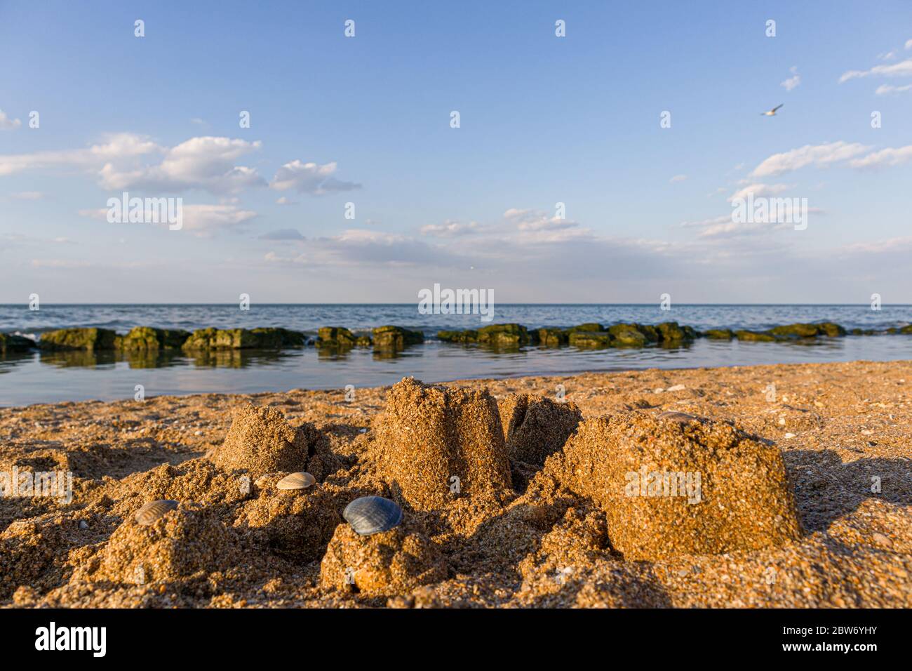 Sand castle with shells standing on the beach. Travel vacations concept ...