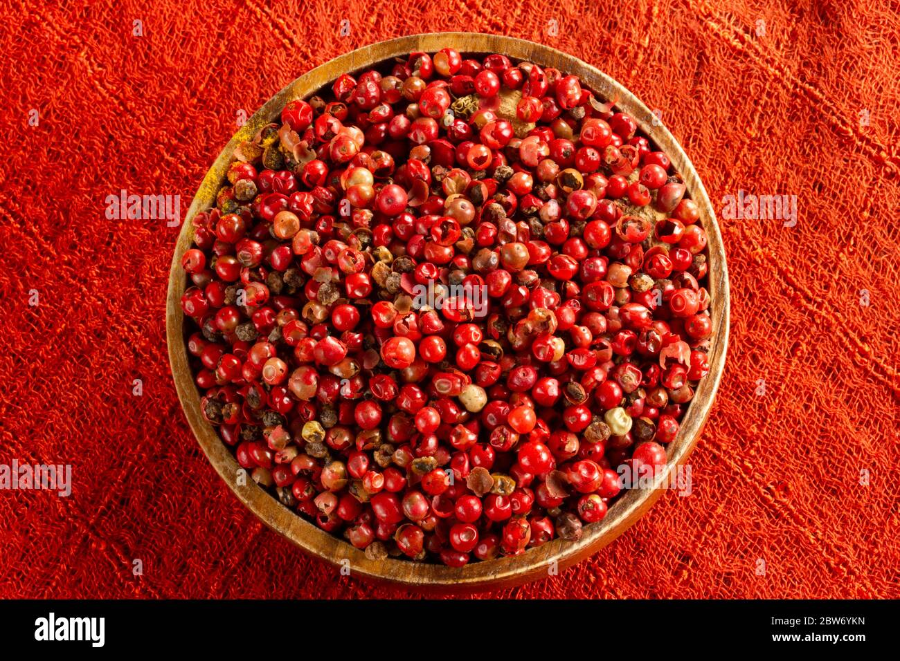 red peppercorn seeds in wooden plate Stock Photo - Alamy