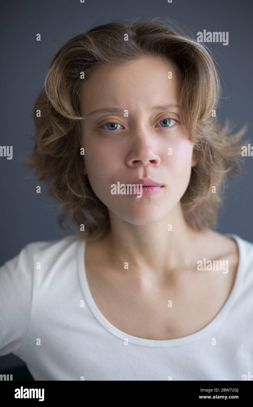 Portrait of young thoughtful lady smirkingly looking in camera Stock ...