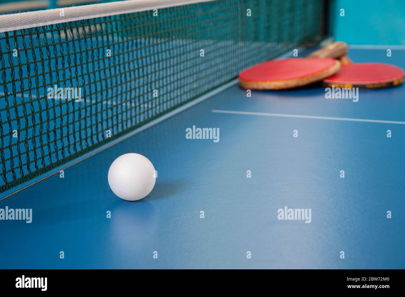 Rackets for table tennis of red color and a ball on a tennis table ...