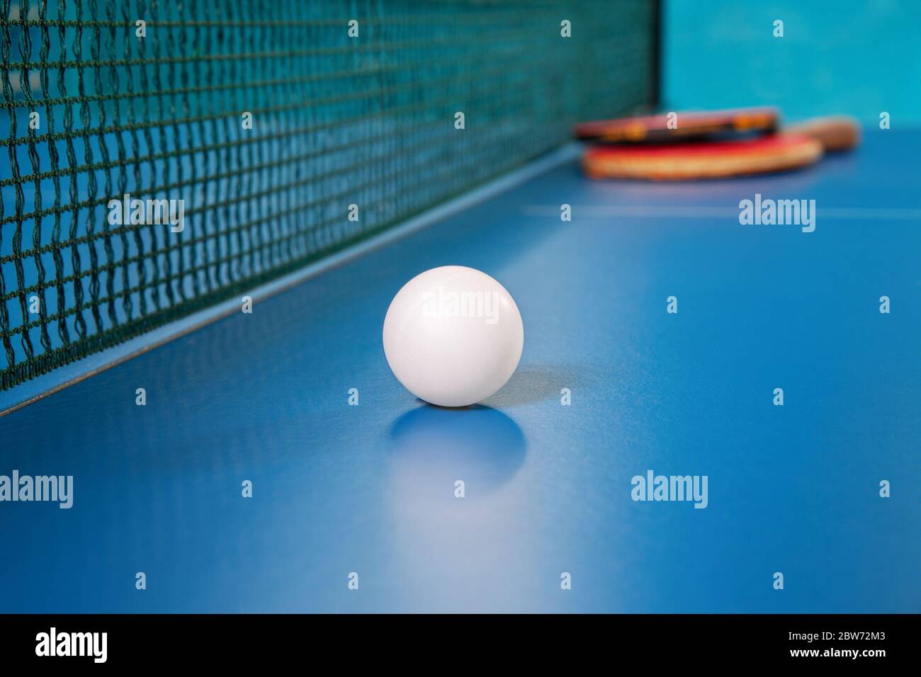 Rackets for table tennis of red color and a ball on a tennis table ...