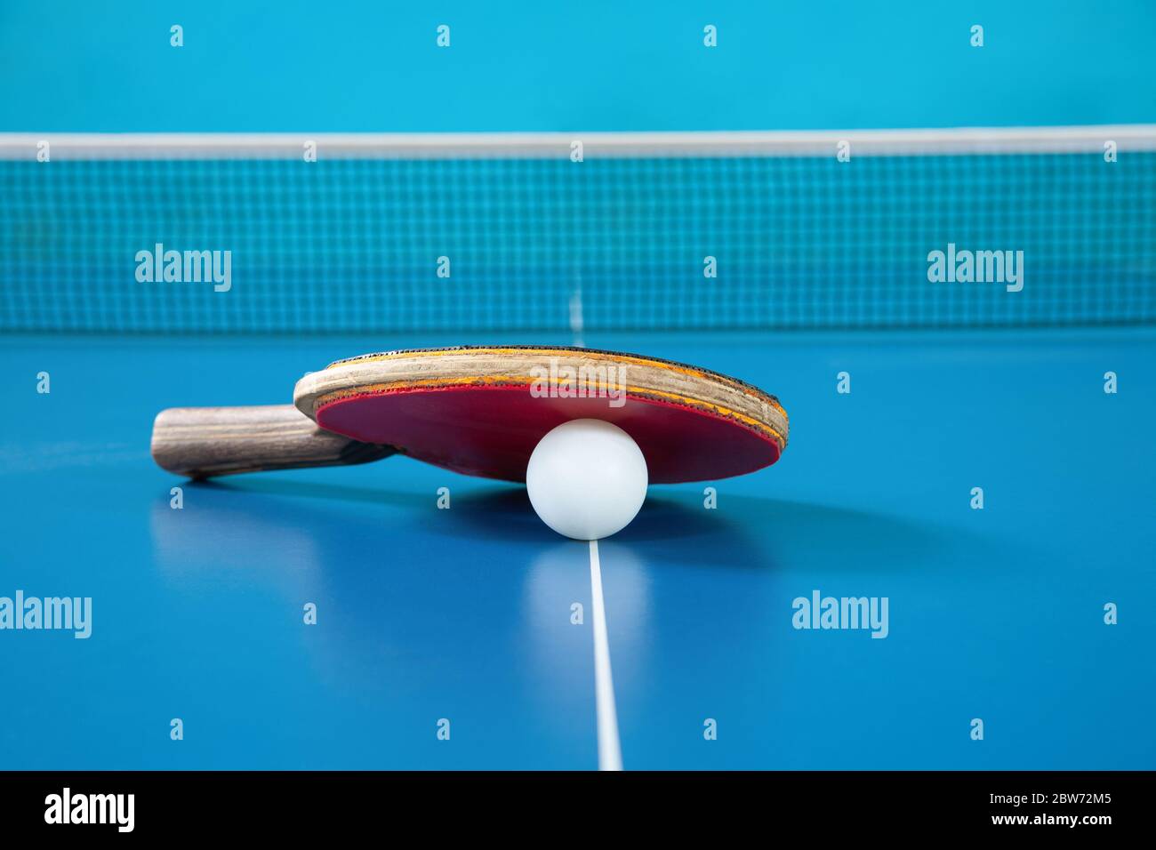 Racket for table tennis of red color and a ball on a tennis table Stock ...