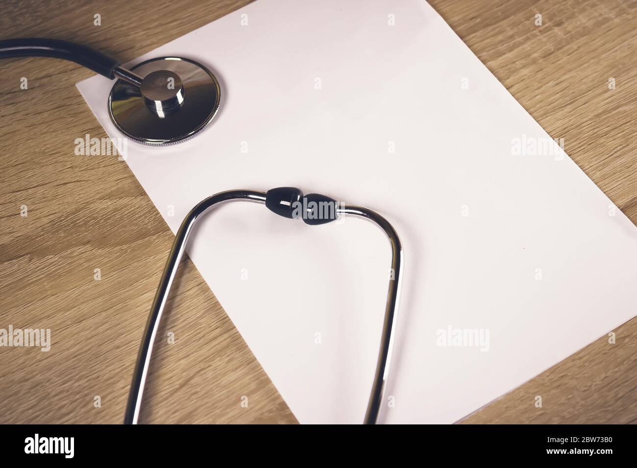 Stethoscope and a piece of paper on a wooden background with copy space ...