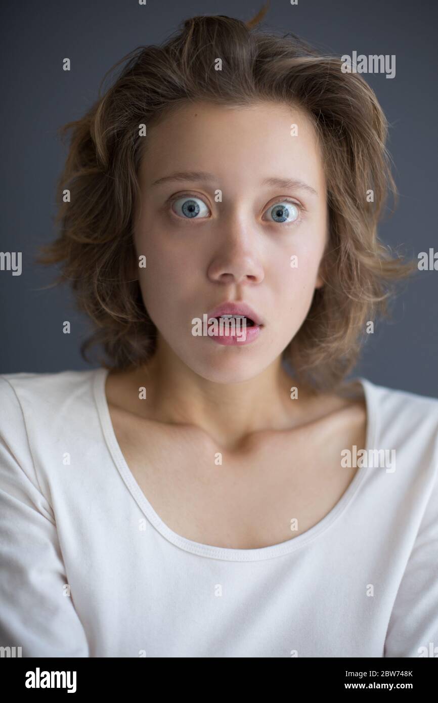 Portrait of young shocked lady amazedly looking in camera Stock Photo ...