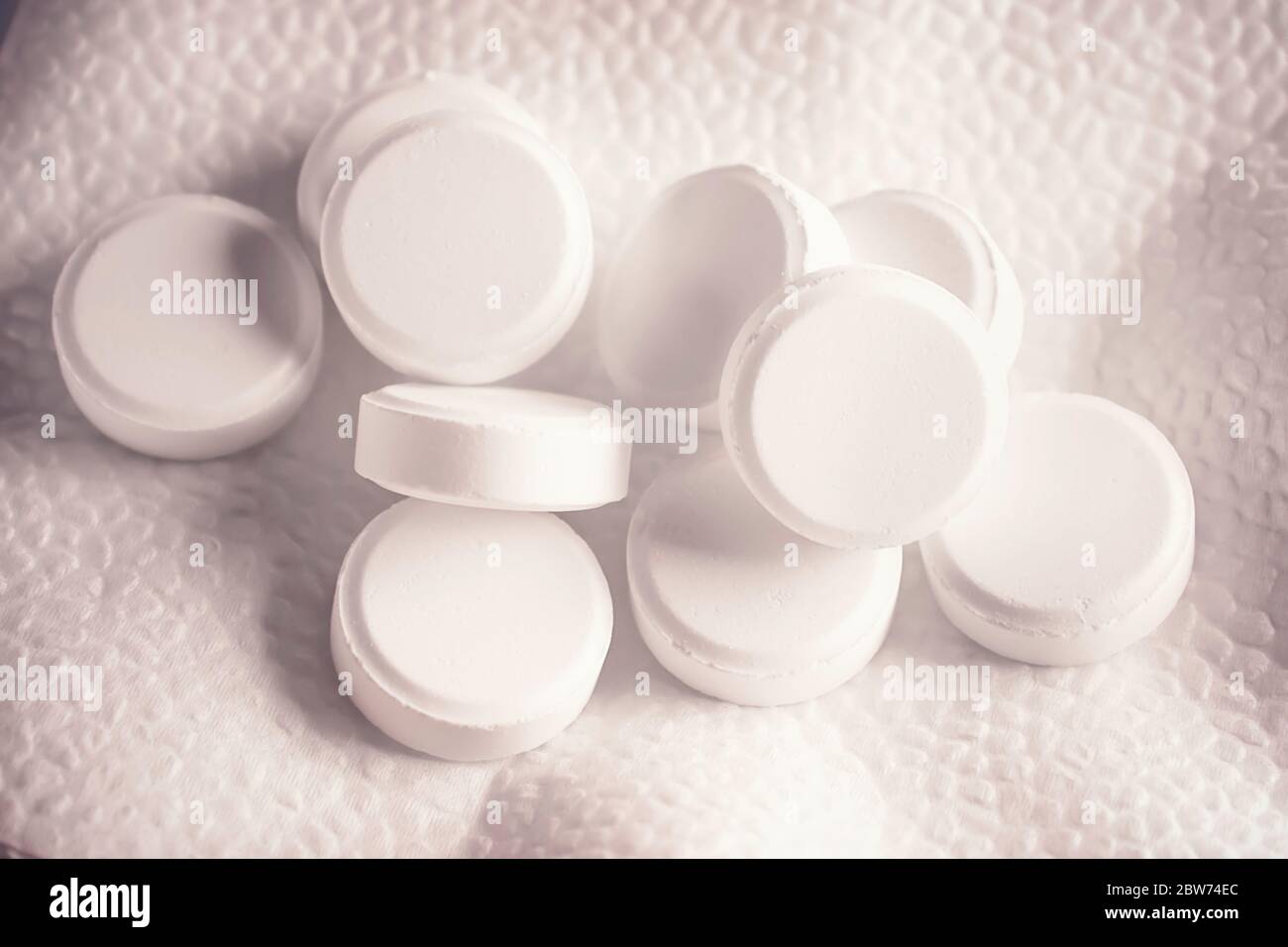 White medication pills lie on a white background. Background image on ...