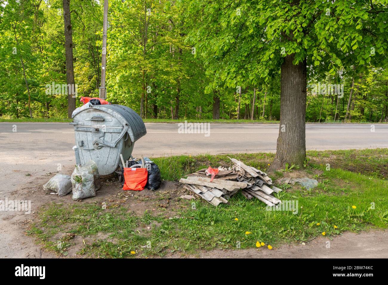 Environmental pollution. Trash container full with garbage along the ...