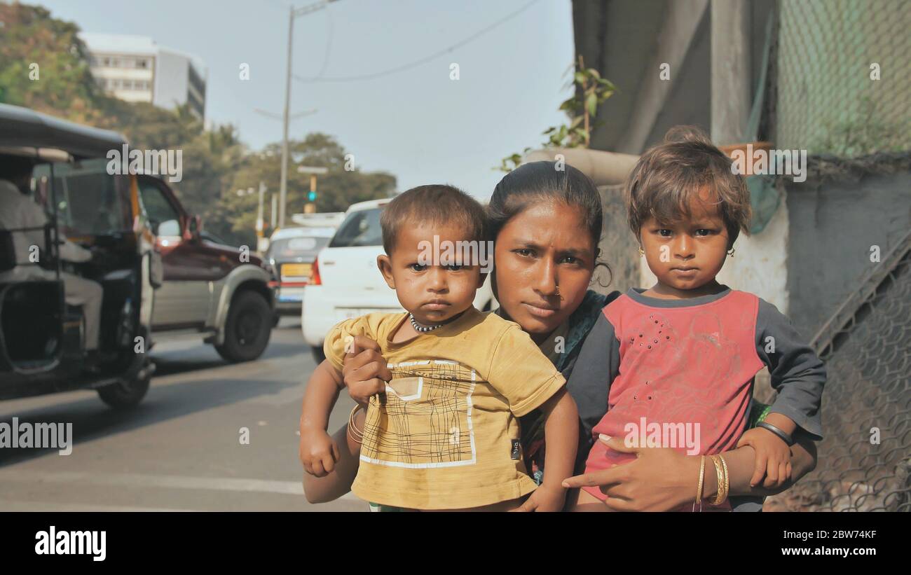 Mumbai, India - December 17, 2018: A homeless young Indian mom with her ...