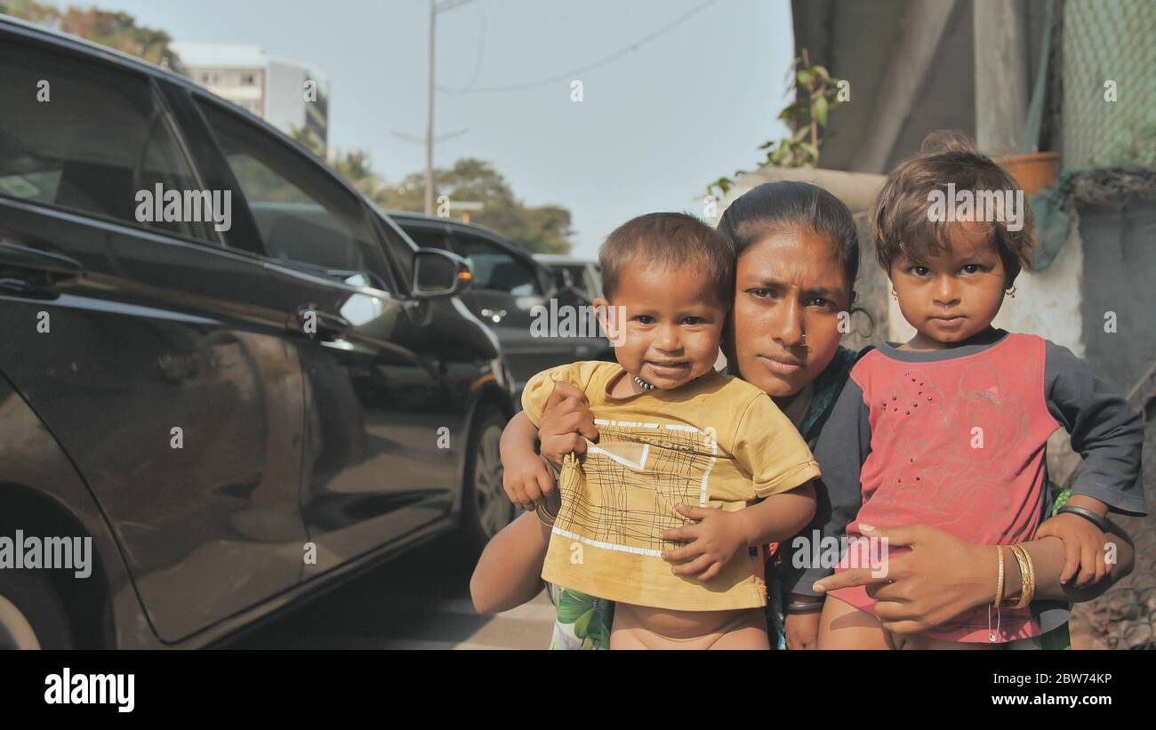 Mumbai, India - December 17, 2018: A homeless young Indian mom with her ...
