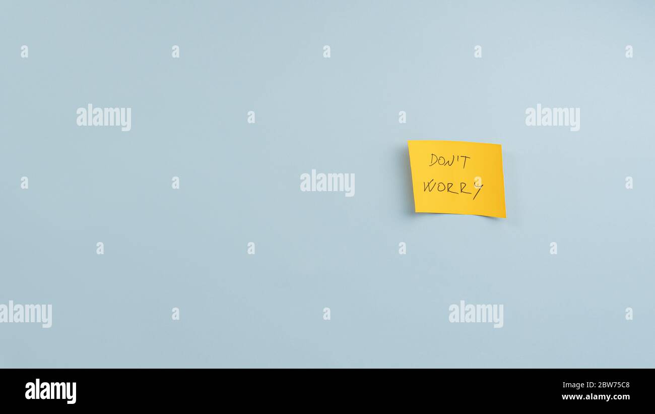 Yellow post it paper with Dont worry sign placed on blue background ...