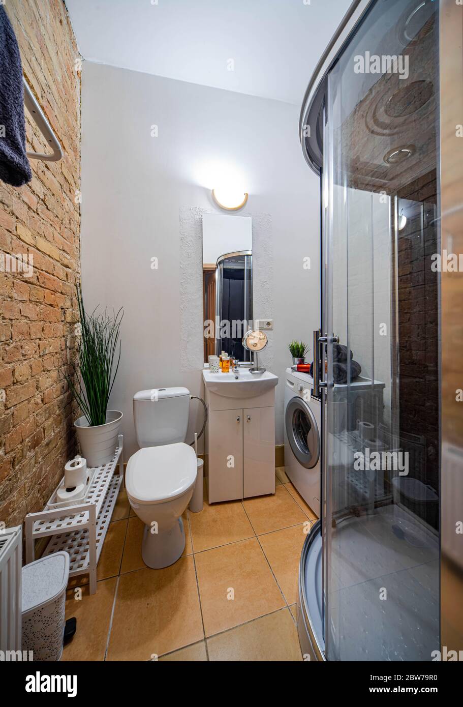 Loft interior of bathroom in apartment. Shower cabin. Washing machine ...