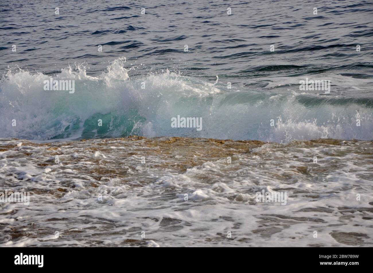 Wave hitting rocks. Wild sea waves at stormy weather Stock Photo - Alamy