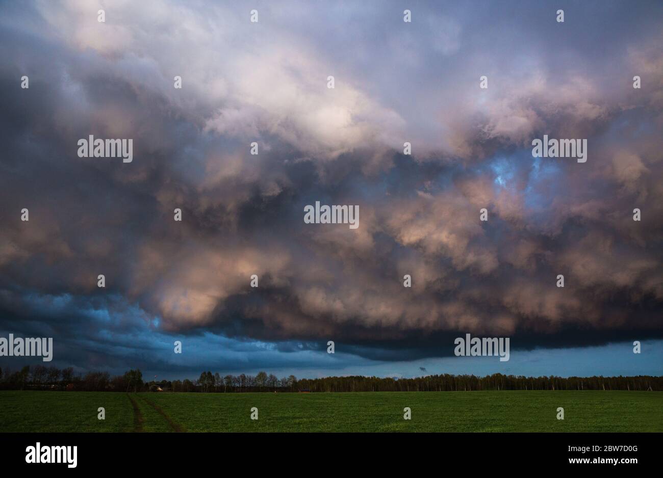 Colorful dramatic red sky with fluffy clouds at sunset before before a ...