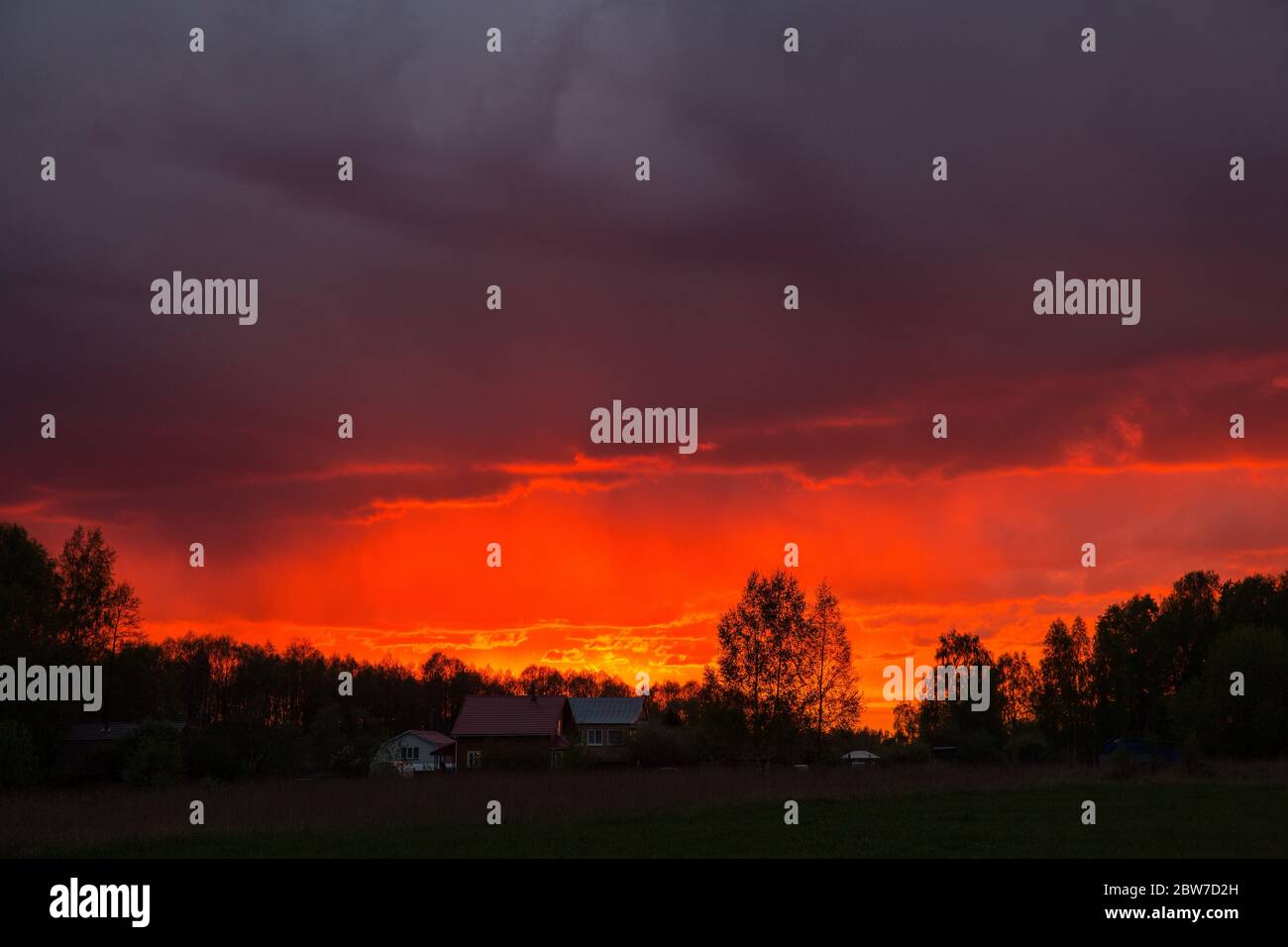Colorful dramatic red sky with fluffy clouds at sunset before before a ...