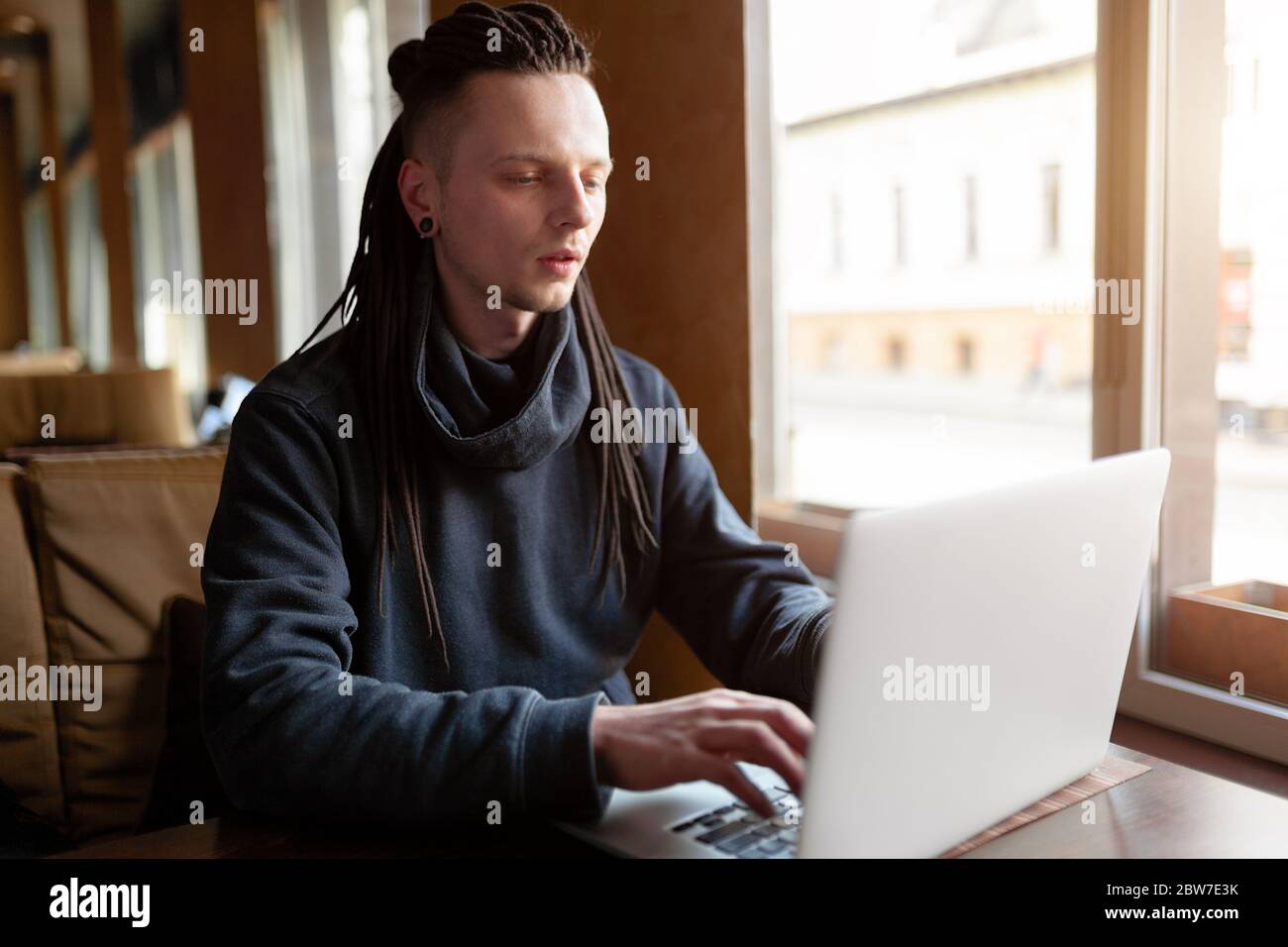 Young Businessman with dreadlock having doing his work in cafe near the ...