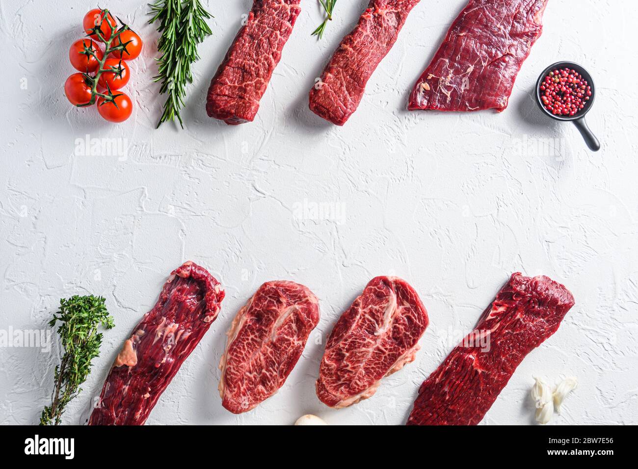 Set of different alternative types of raw beef steaks,on a white stone ...