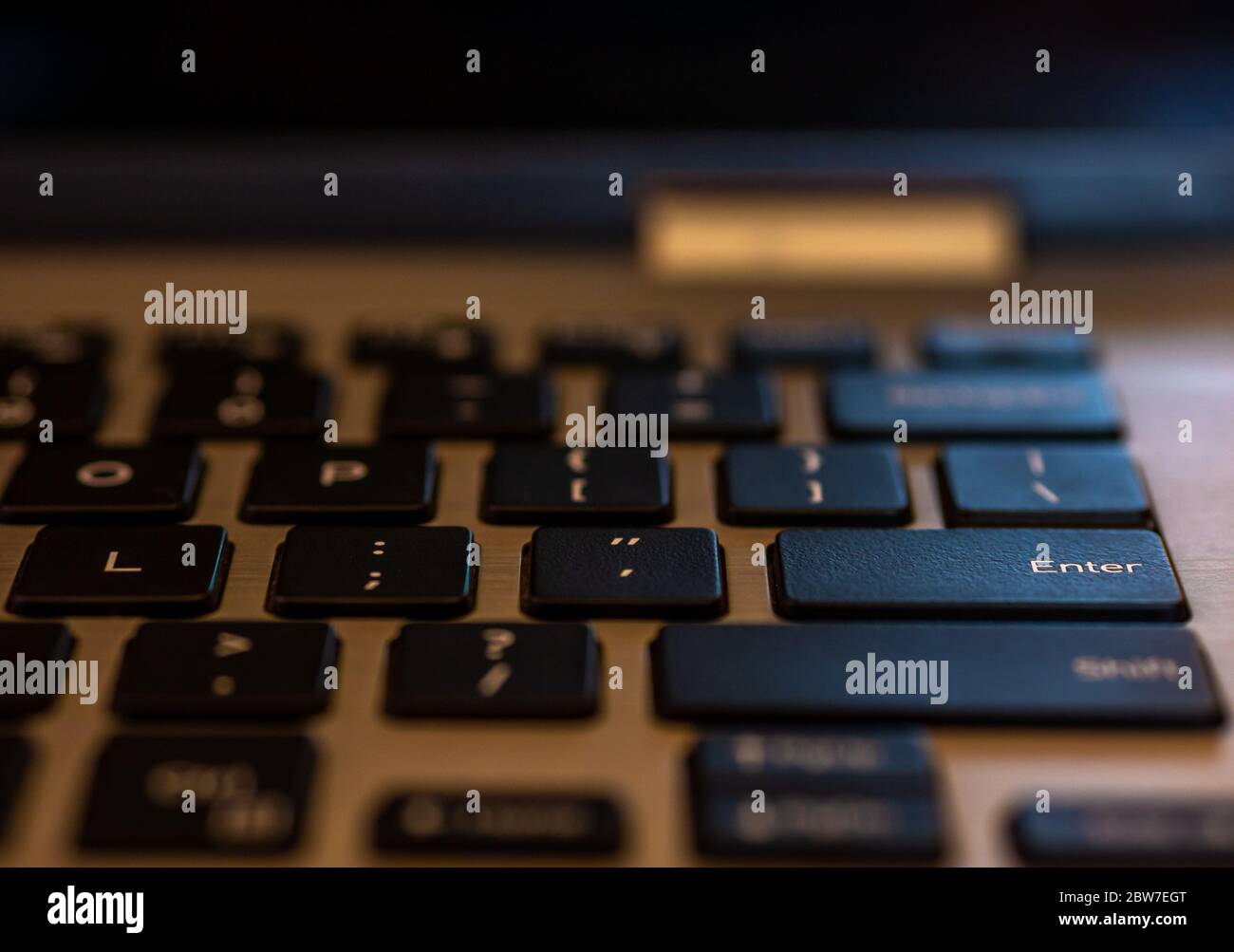 Closeup of laptop keyboard, Black keys on silver laptop. Enter key in ...