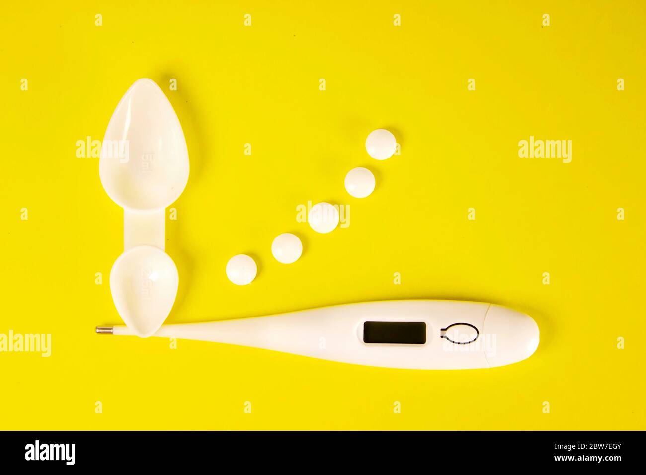 Measuring spoon for medicines, thermometer and tablets as background ...
