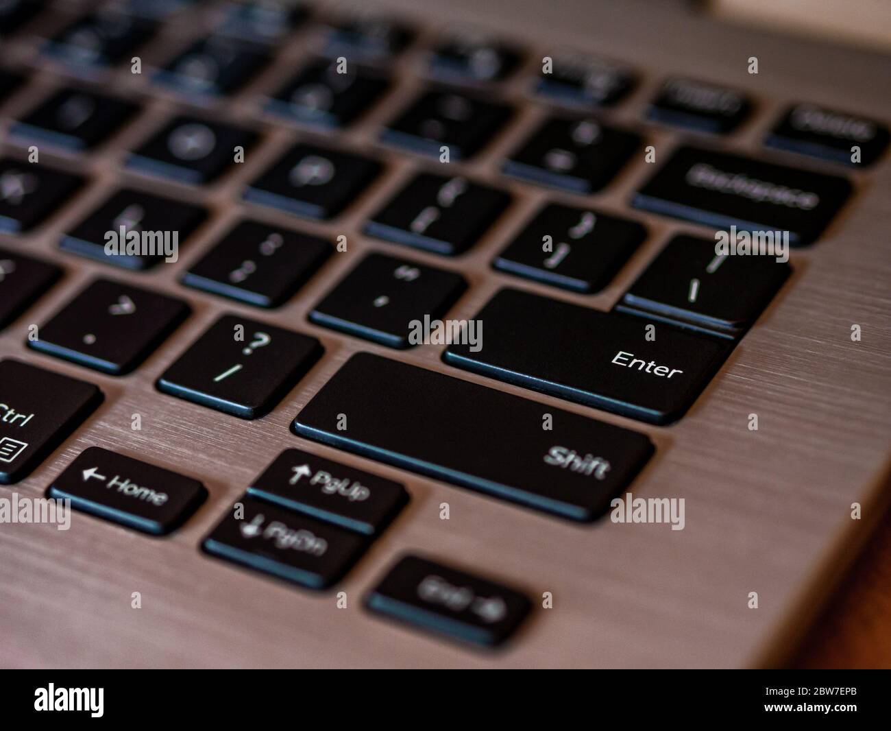 Closeup of laptop keyboard, Black keys on silver laptop. Enter key in ...
