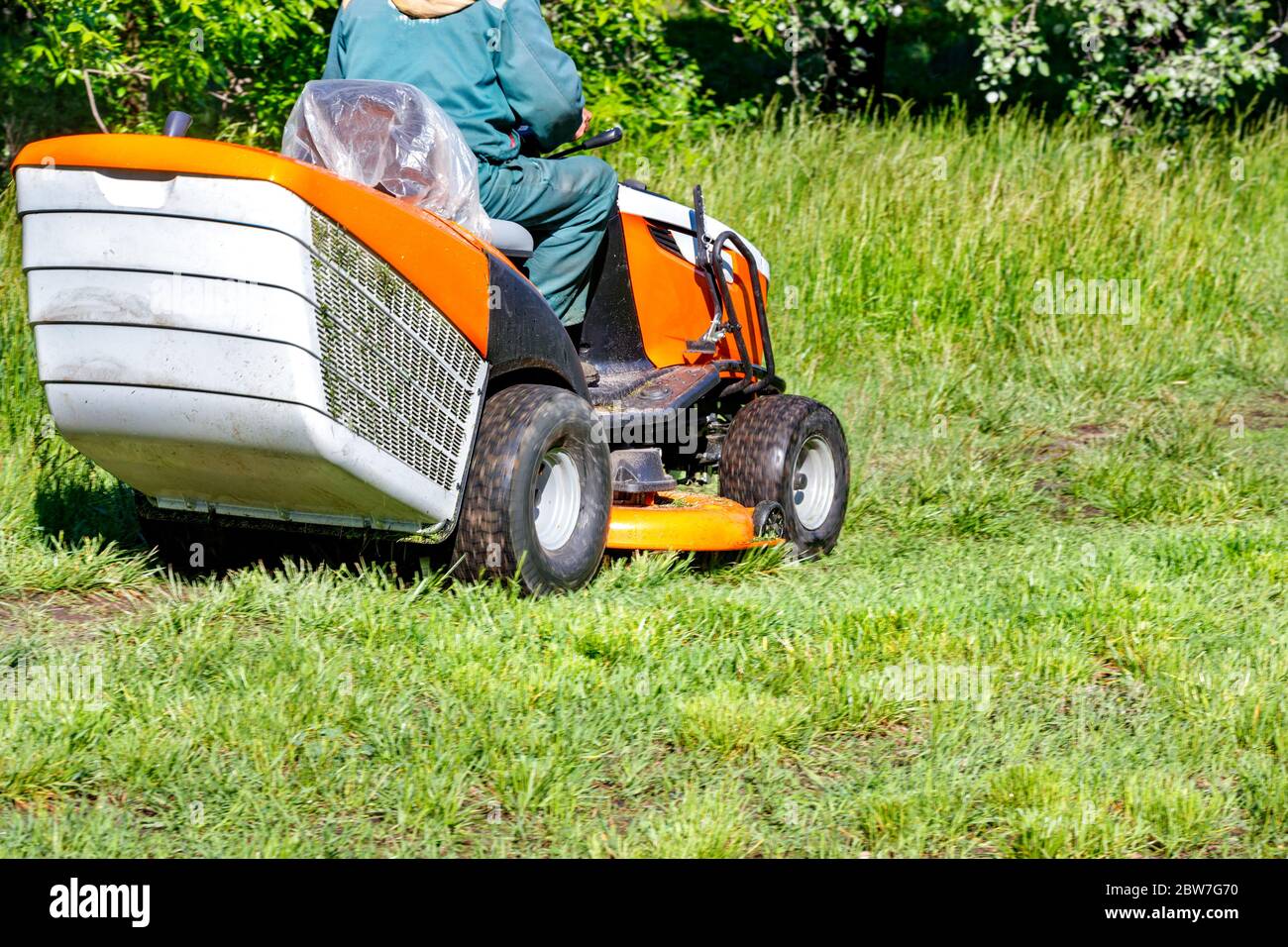 A well-kept park with a trimmed lawn as a result of a gardener working ...
