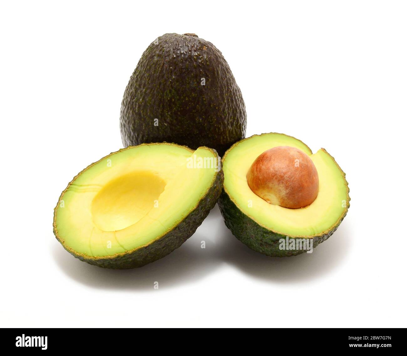 Fresh two avocado, one halved and one whole, over white background ...