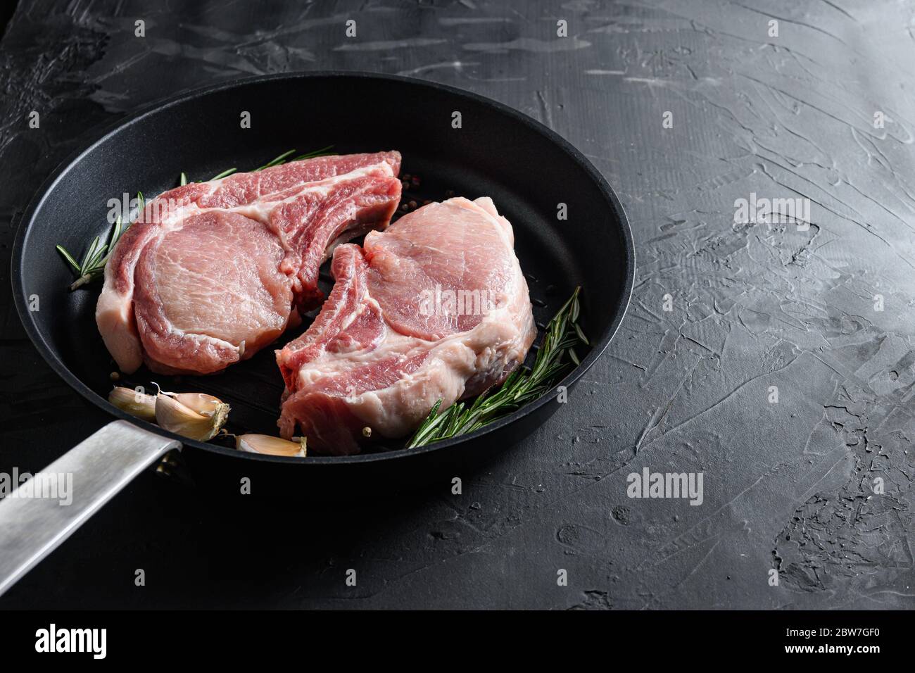pork rib chops in frying pan grill skillet with herbs, spices side view ...