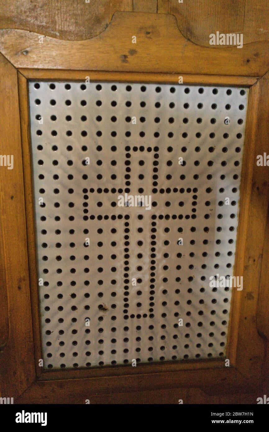 Grid of a confessional in a Christian church, with the symbol of the ...