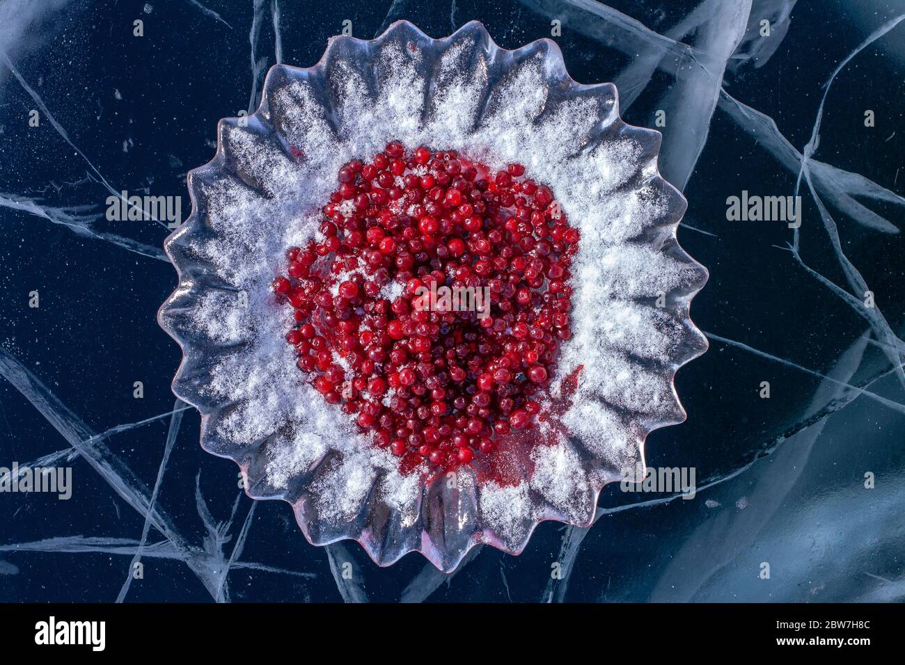 Gorgeous dark ice with cracks and an ice dish with cranberries. Red ...