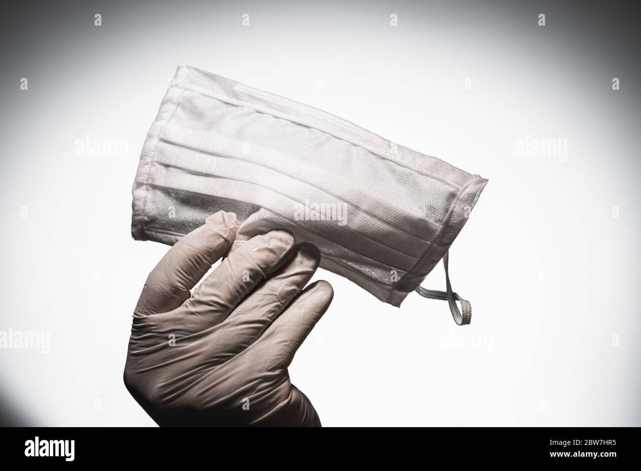Hand holding medical mask on white background Stock Photo - Alamy