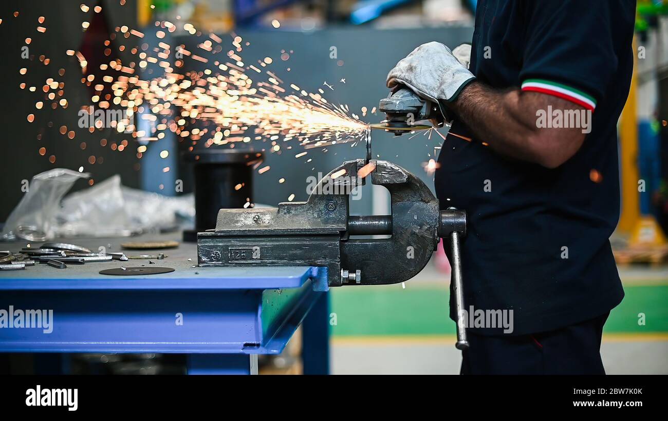 Worker operating an angle grinder and making lots of sparks, closeup ...