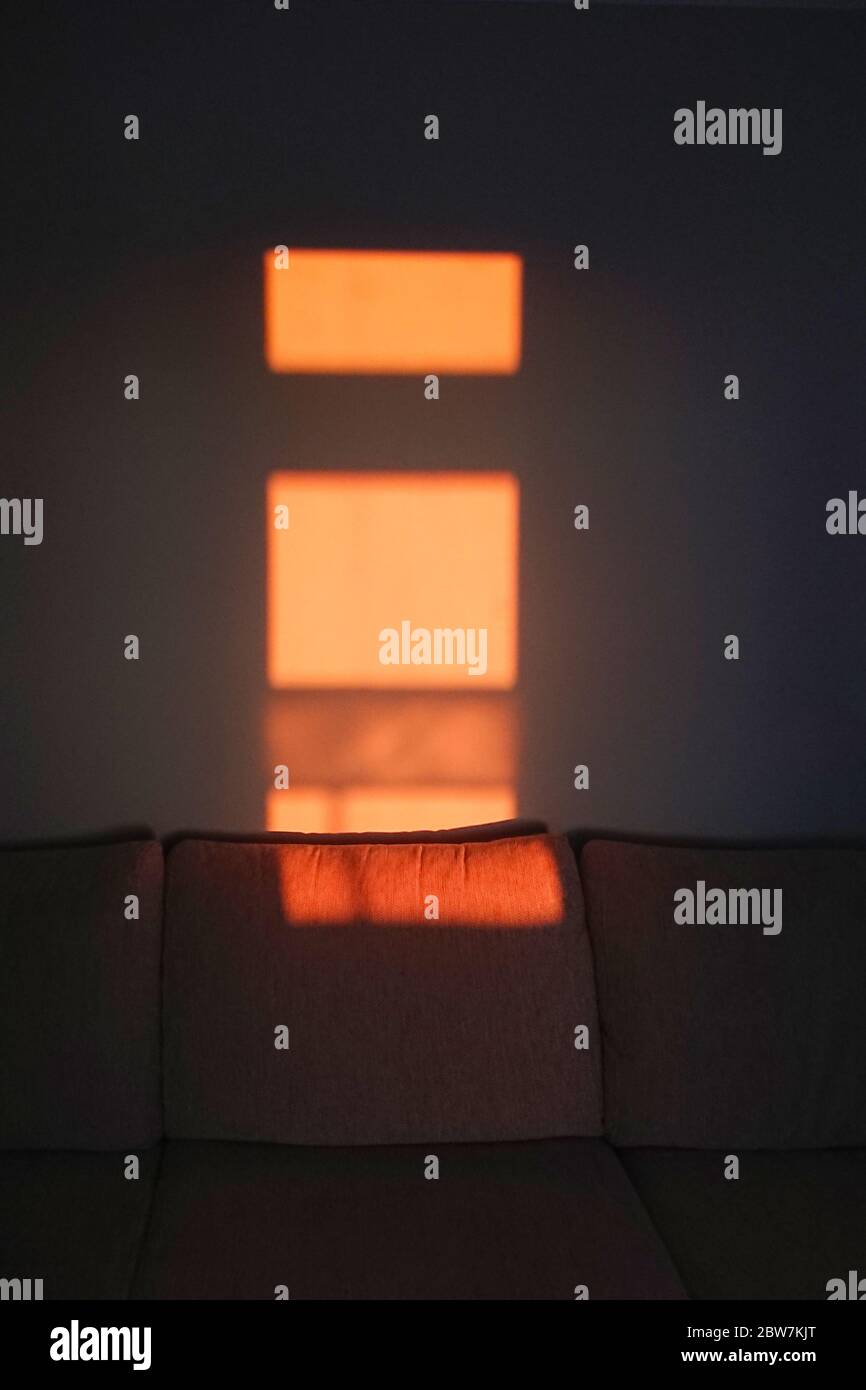 Abstract shadow silhouette of window frame from sunbeam on wall in room ...