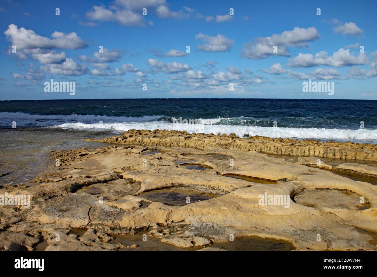 The rock pools in the sandstone shelf on the beach at Sliema, Malta ...