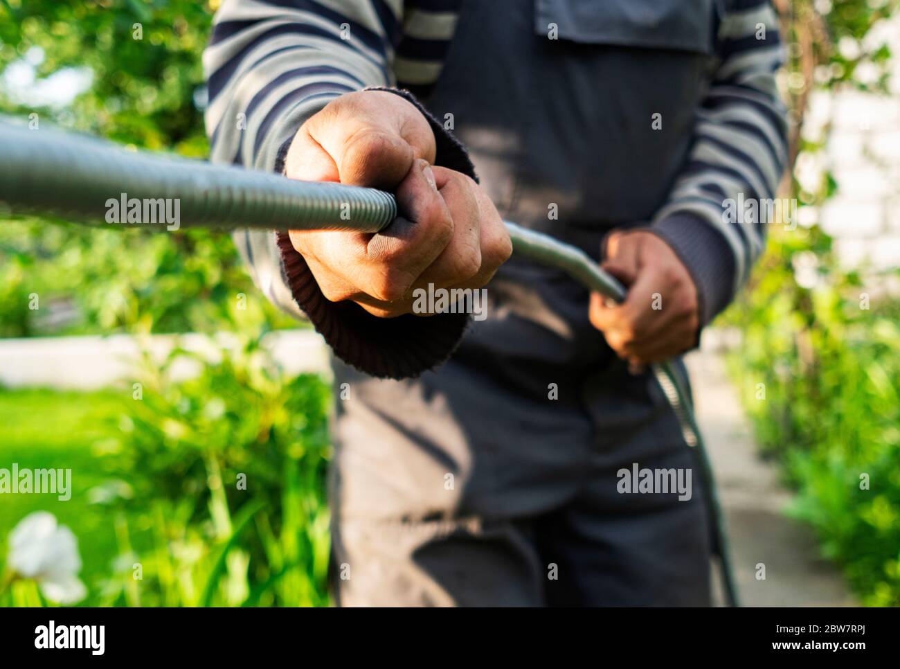 Adult Caucasian male pulls cable through metal protective sleeve Stock ...