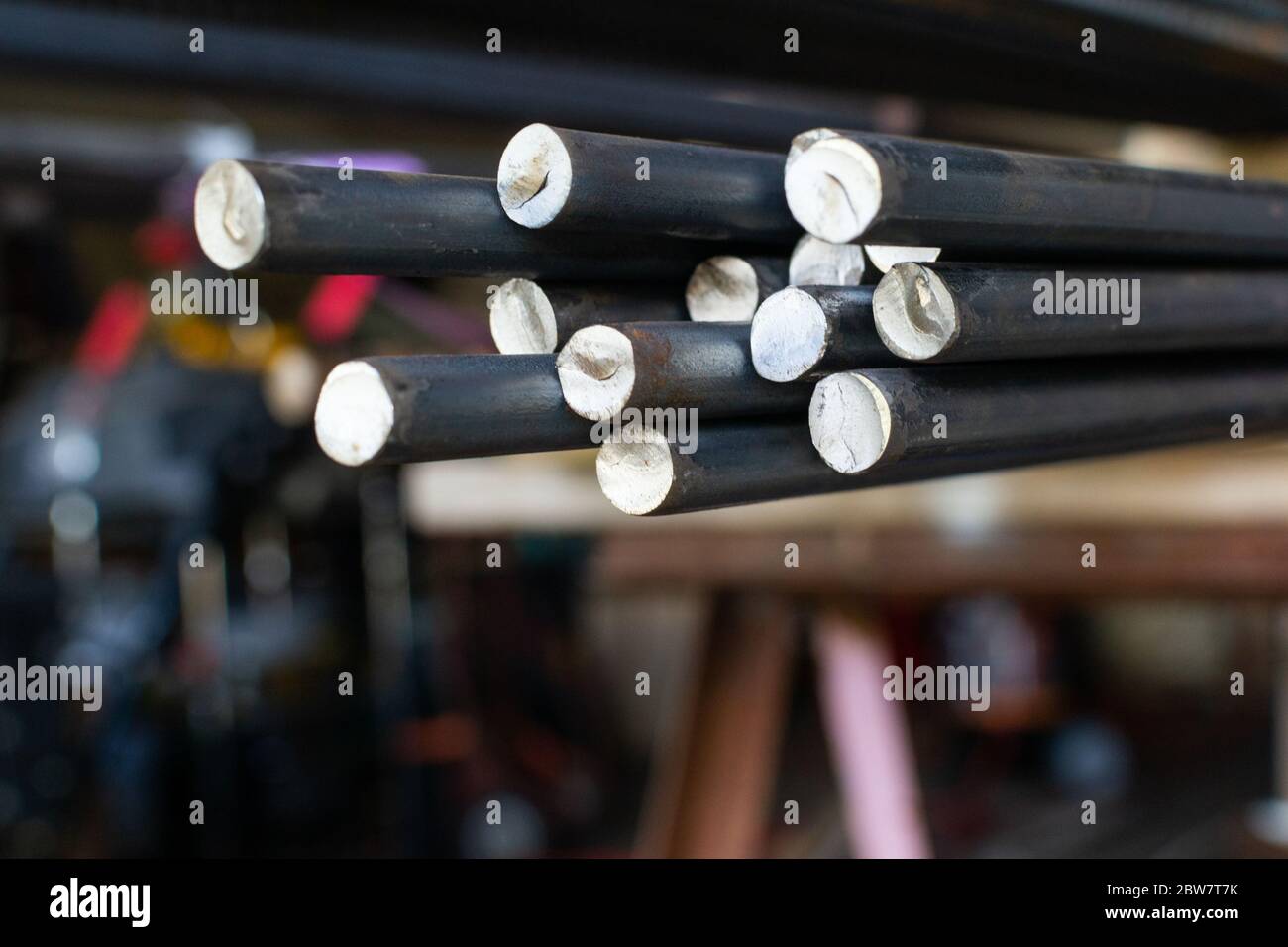 a close up of a bundle of steel round bar in a machine shop Stock Photo ...