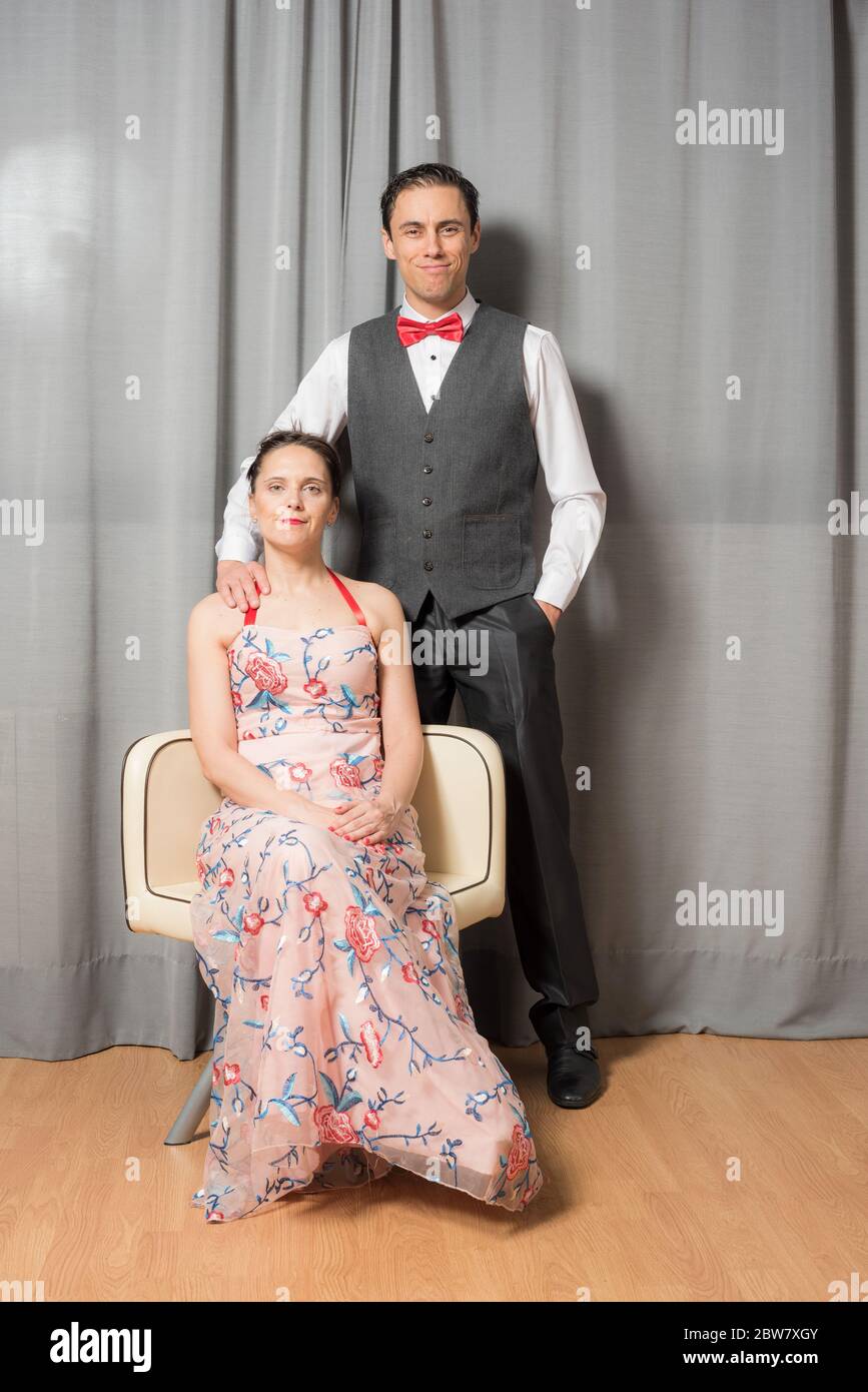 Portrait of smiling upper class marriage. The woman, seated in an ...