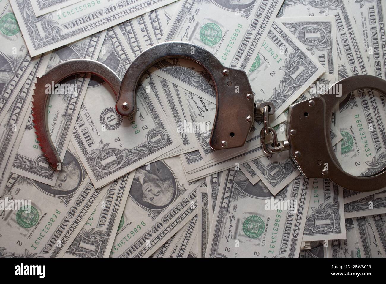 handcuffs sitting on top of US paper currency Stock Photo - Alamy