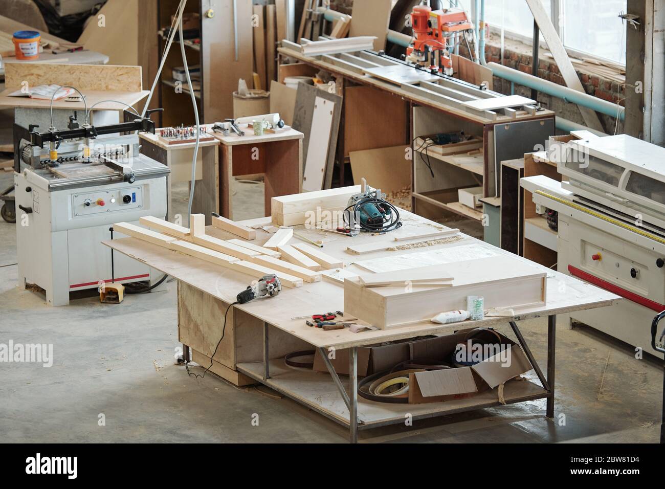 Workbench of furniture factory worker with wooden workpieces, electric ...