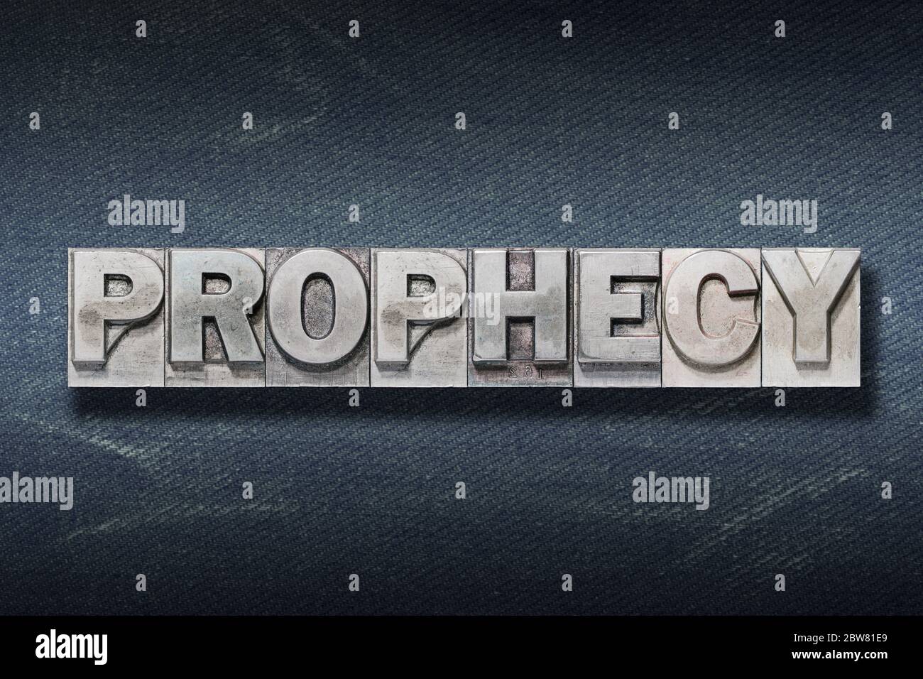 prophecy word made from metallic letterpress on dark jeans background ...