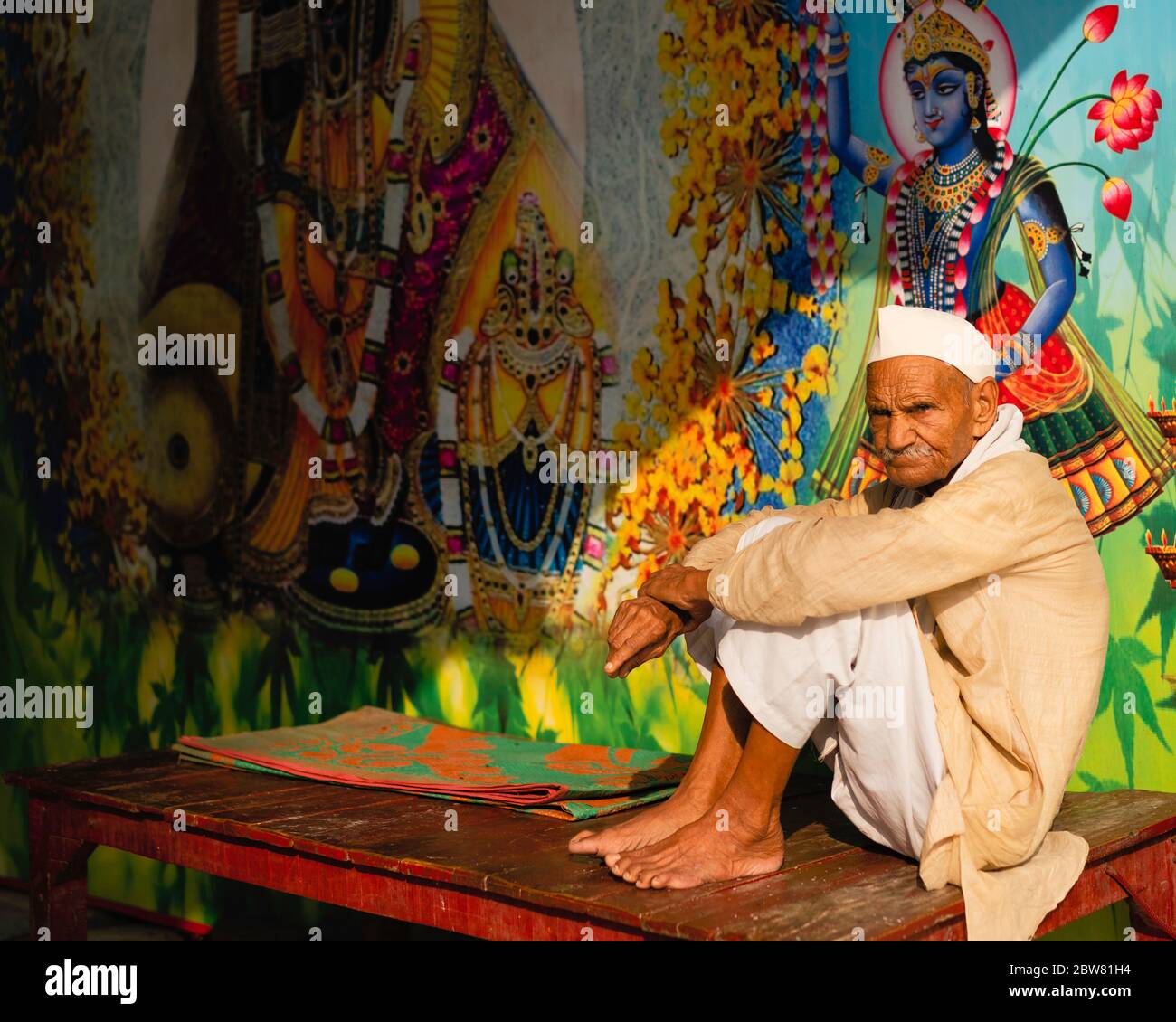 Candid portrait of man wearing Nehru hat sitting in Hindu temple ...