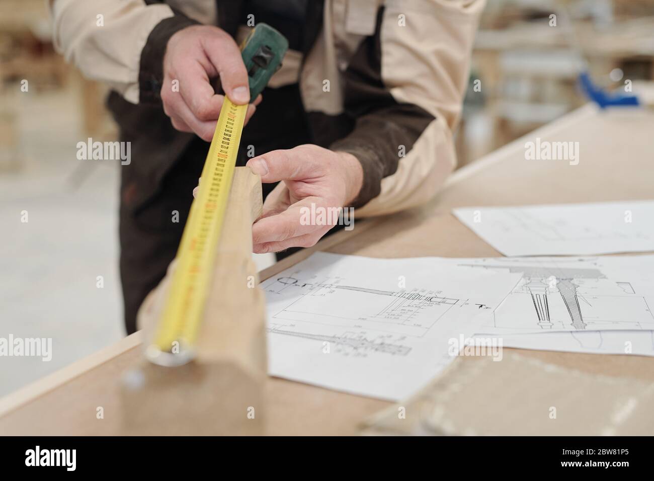Hands of contemporary worker of factory holding wooden workpiece and ...