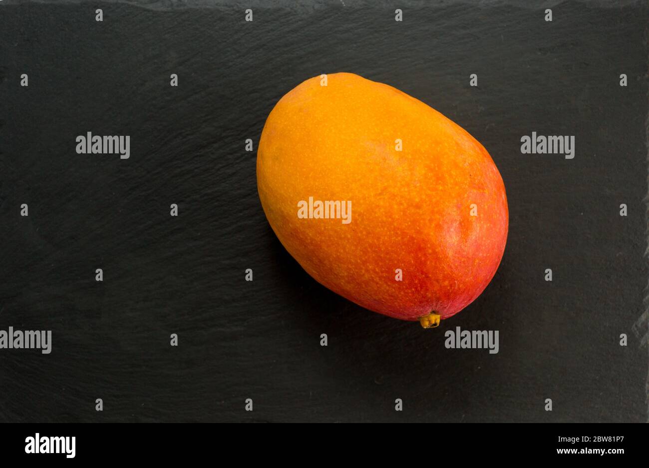 One mango fruit on the dark background. Minimalistic concept Stock ...