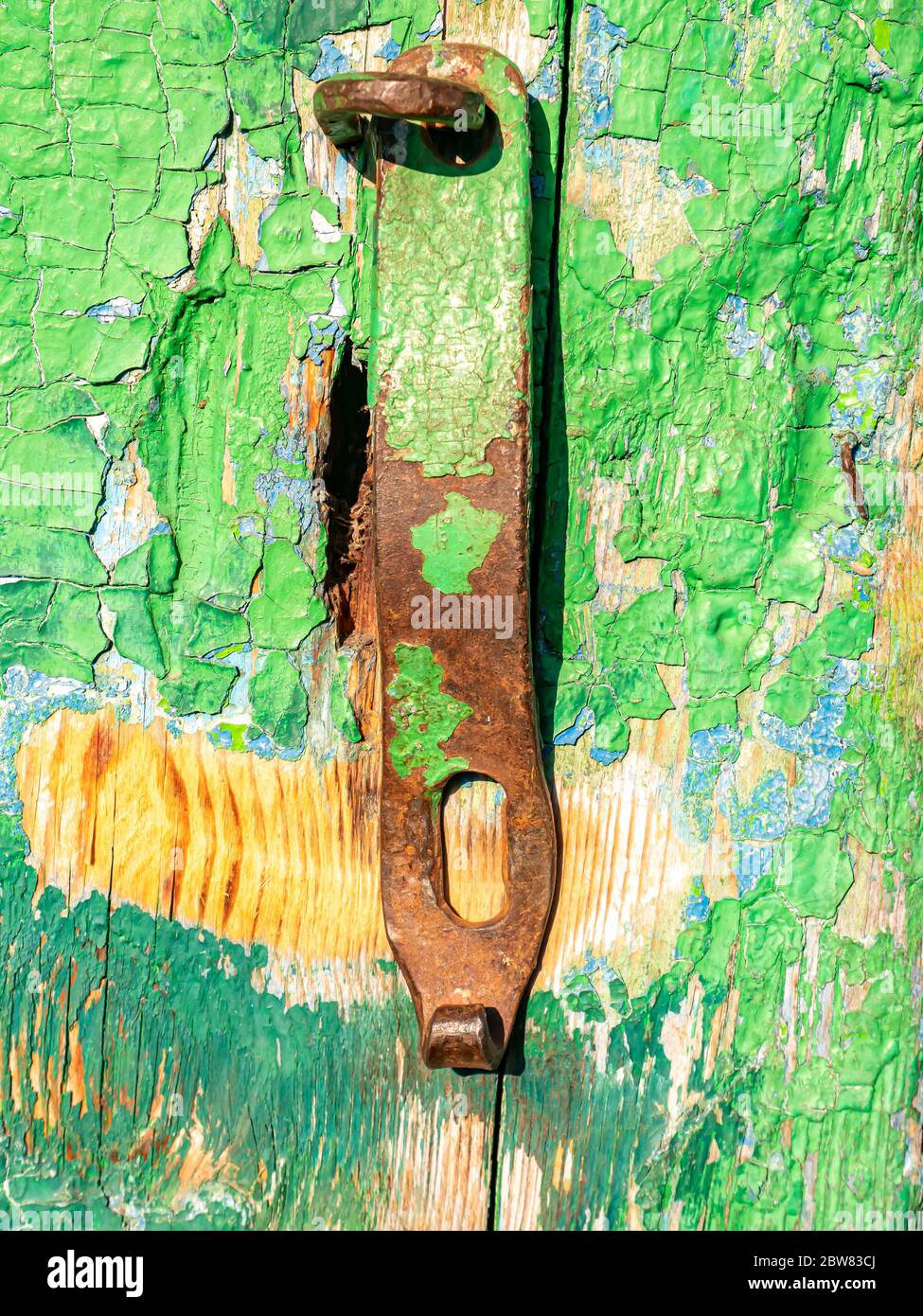 Fastening a metal hinge for a padlock of a wooden door Stock Photo - Alamy