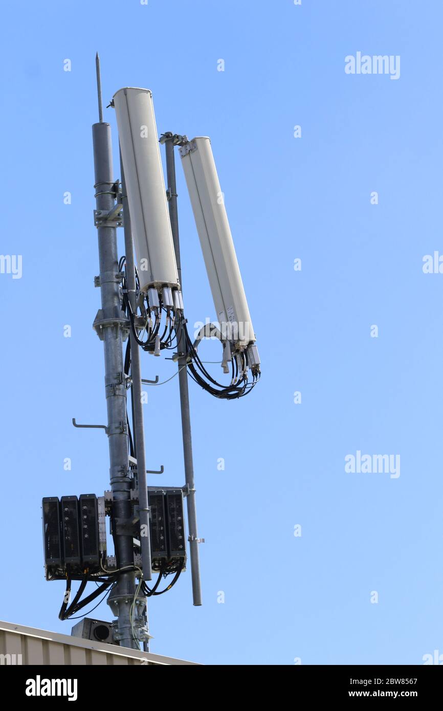Cellular, mobile phone transmitter tower with blue sky and clouds middle Stock Photo - Alamy