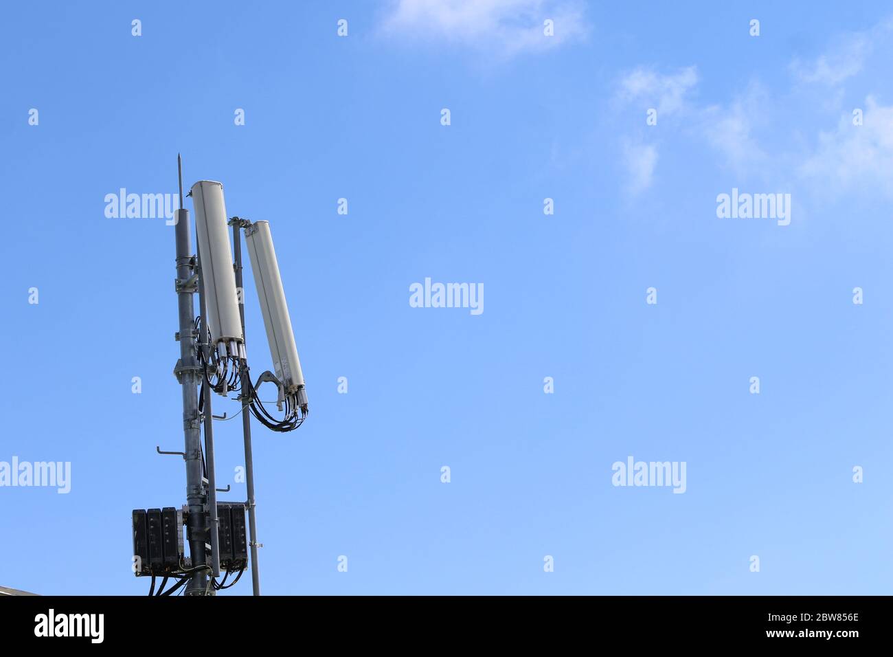 Cellular, mobile phone transmitter tower with blue sky and clouds middle Stock Photo - Alamy
