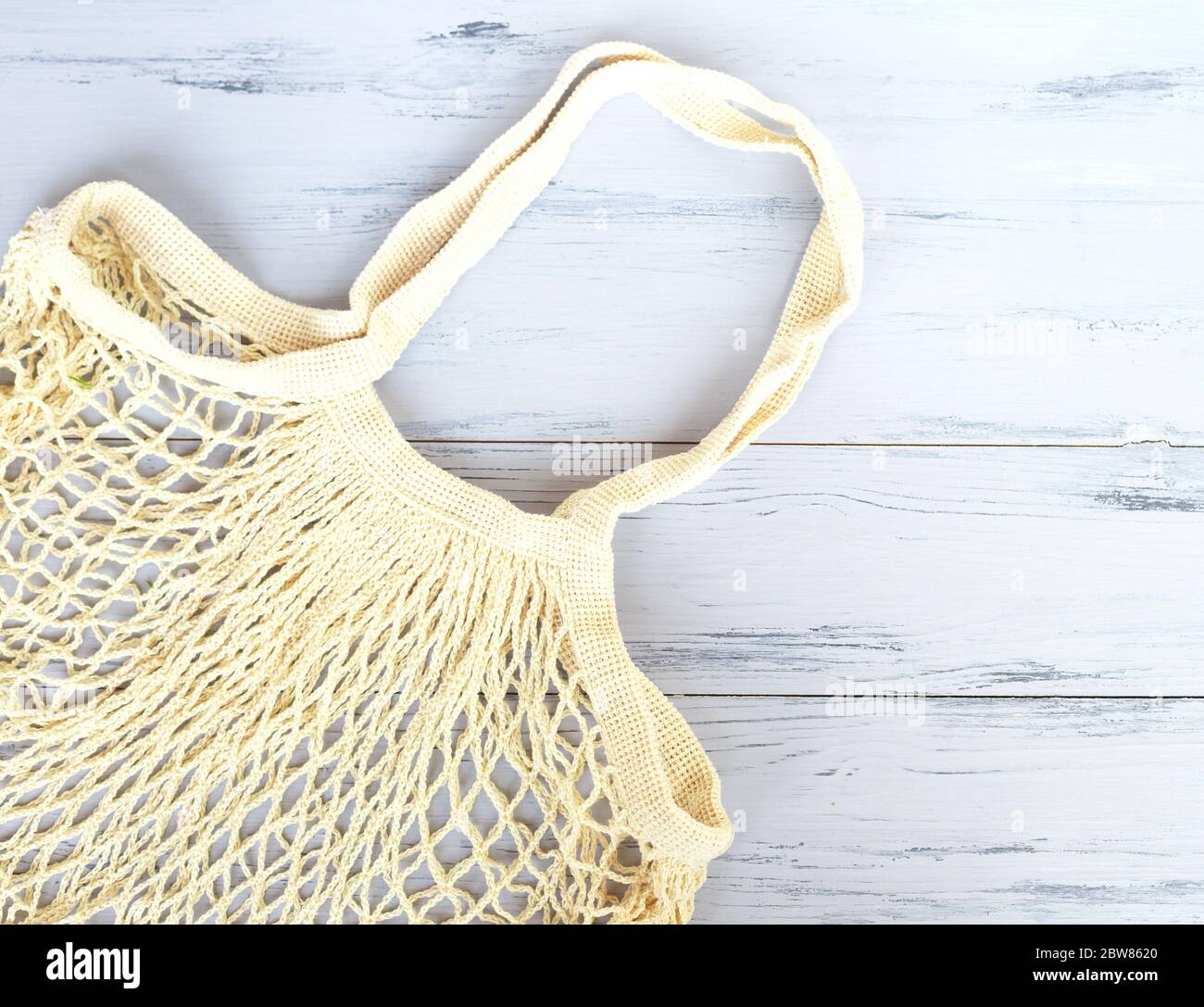 Empty beige net bag on wooden background Stock Photo - Alamy