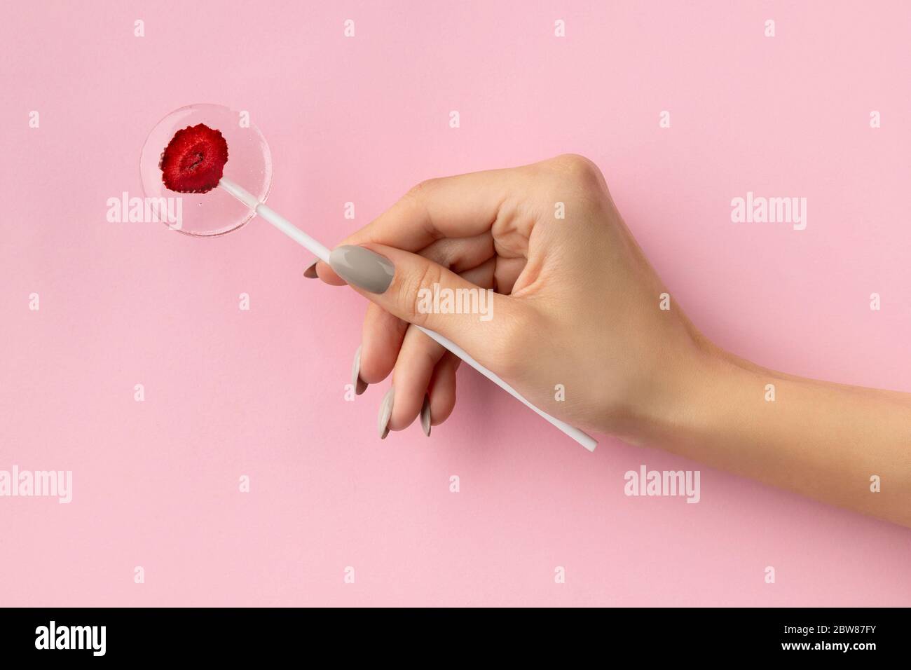 Hand holding lollipop hi-res stock photography and images - Alamy
