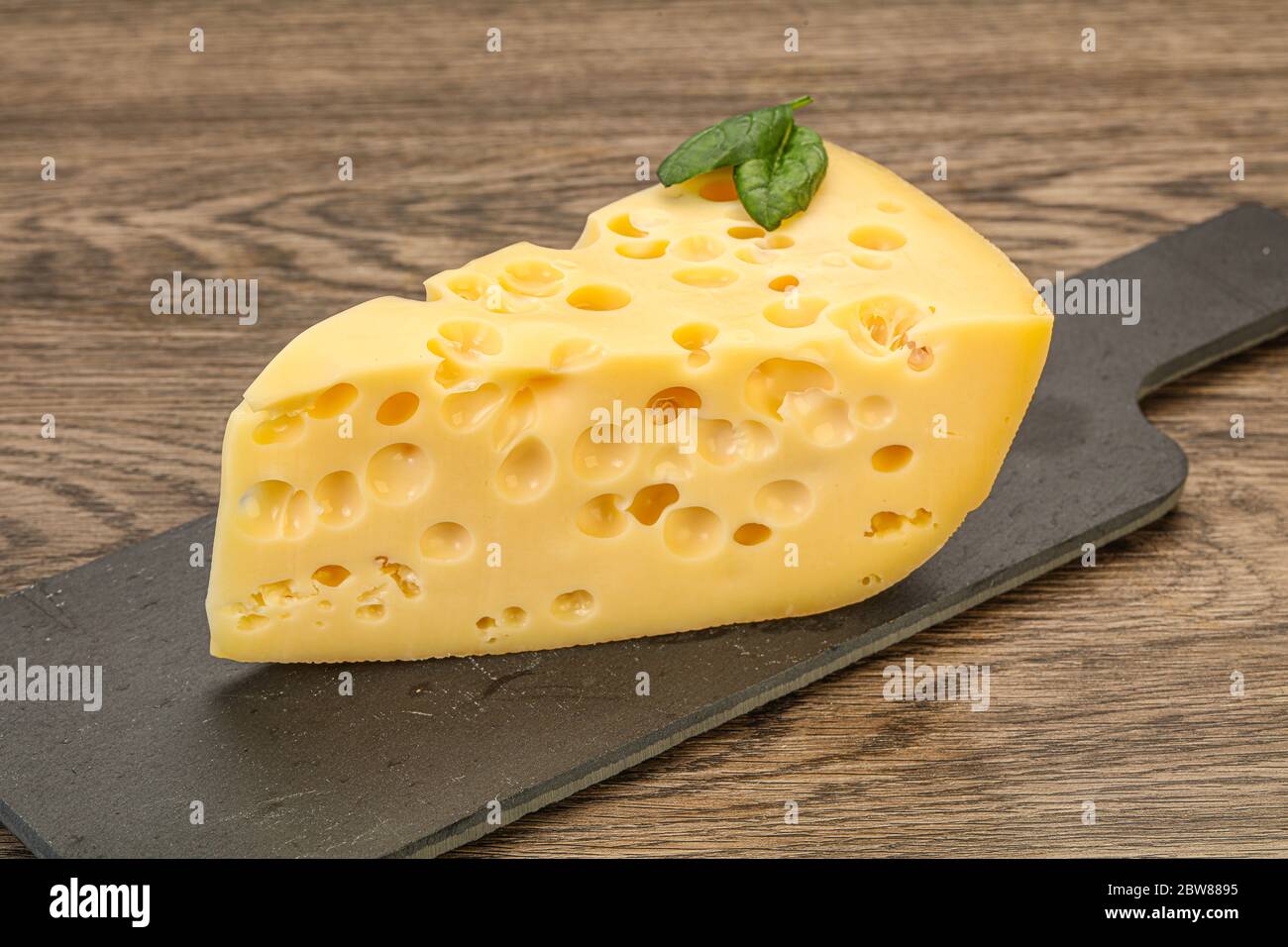 Maasdam cheese - dairy yellow triangle with holes Stock Photo - Alamy