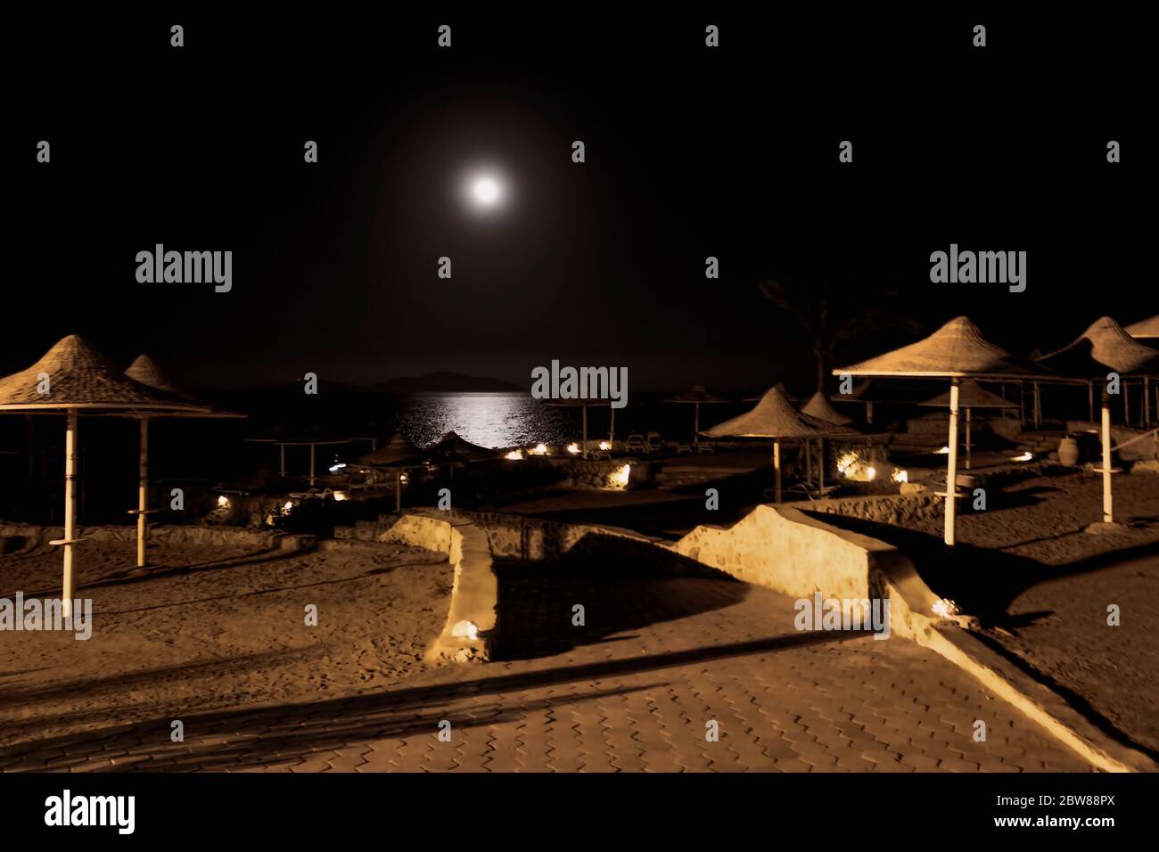 A beach on the Red Sea at night lit by lanterns and the moon Stock ...