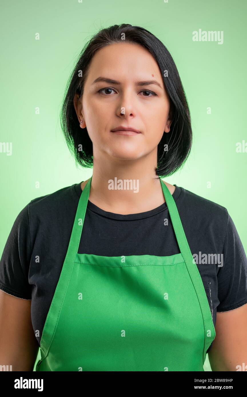 Female cook with green apron and black t-shirt, isolated on green ...