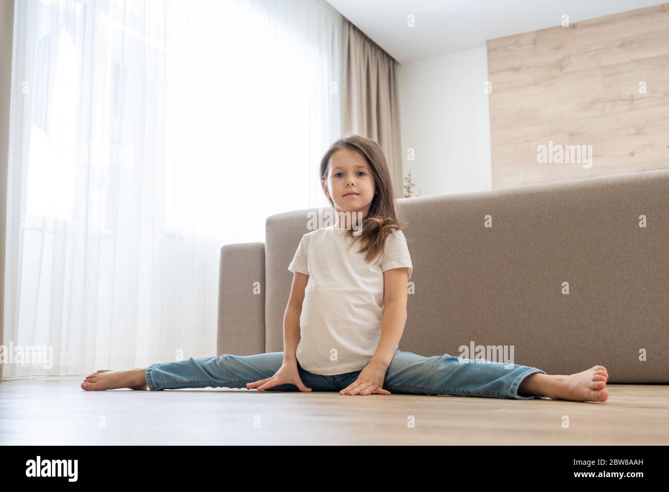 Little girl doing split in living room at home Stock Photo - Alamy